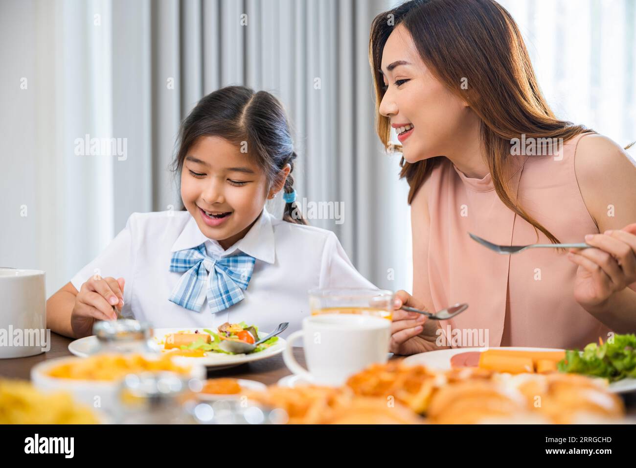 Mom and little preschooler have fun eating meal together Stock Photo ...