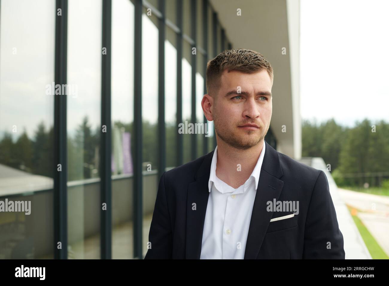 A CEO dressed in a sleek black suit stands confidently at the entrance ...