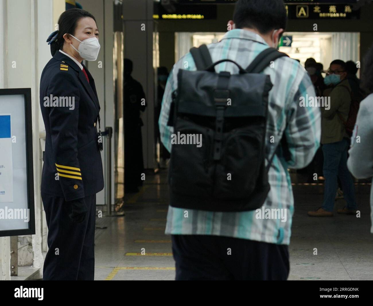 220517 -- BEIJING, May 17, 2022 -- A staff member reminds passengers of ...