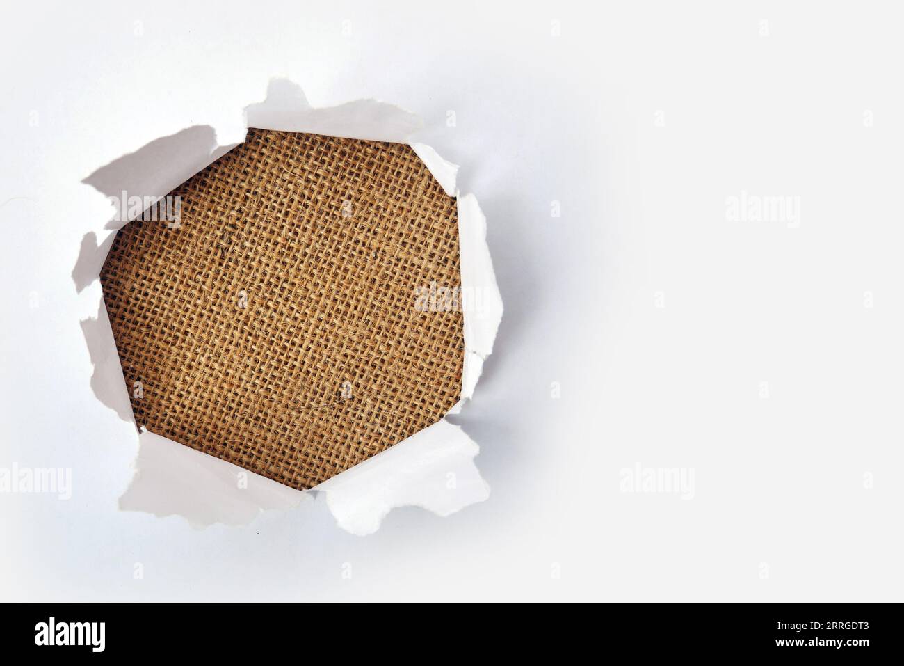 Big paper hole in the middle of burlap background. Blank space to ...