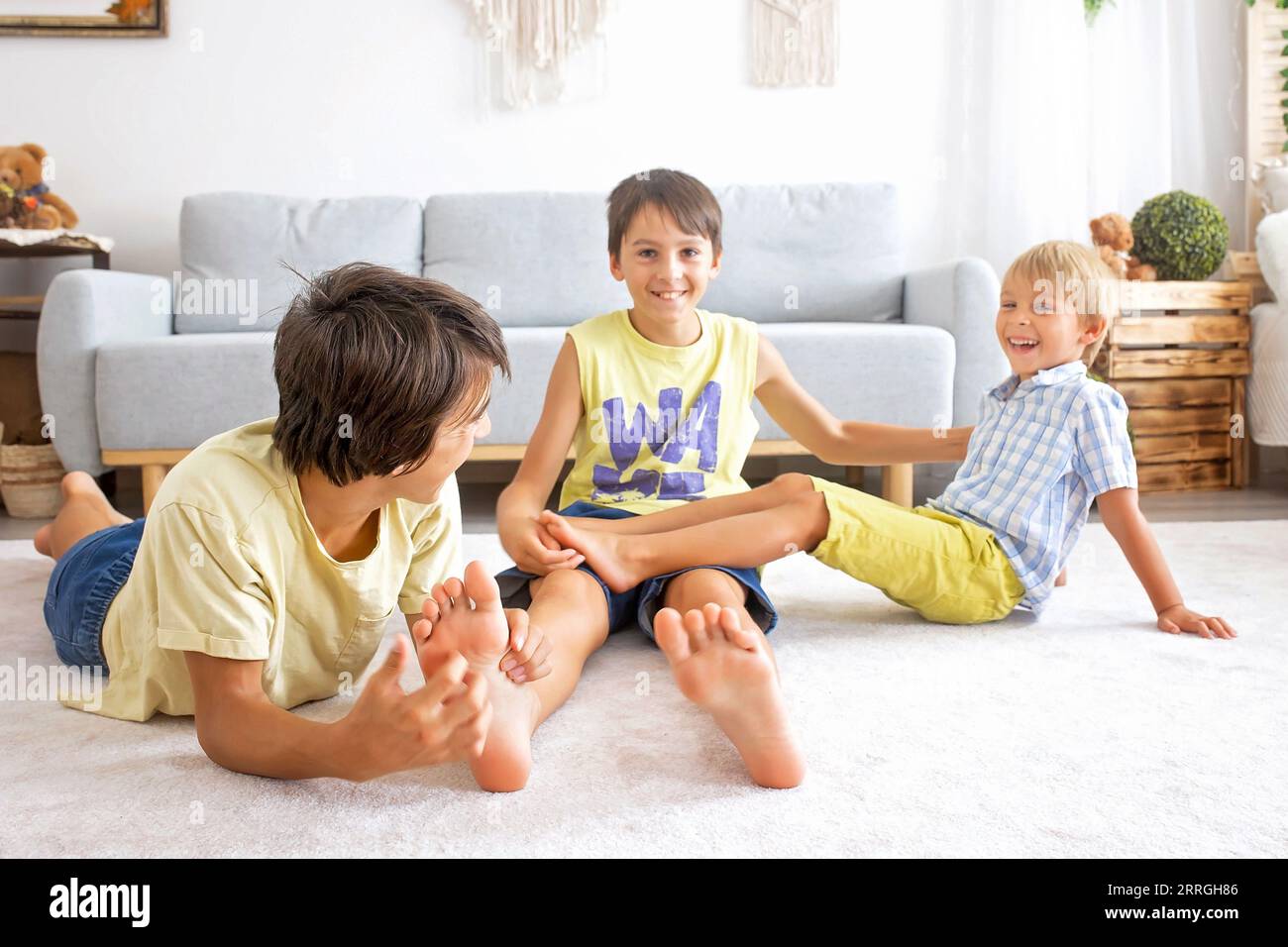 Happy positive children, tickling on the feet, having fun together, boy ...