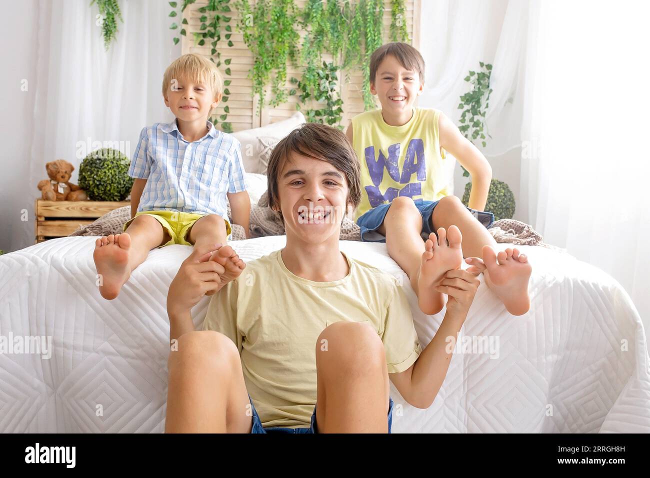 Happy positive children, tickling on the feet, having fun together, boy ...