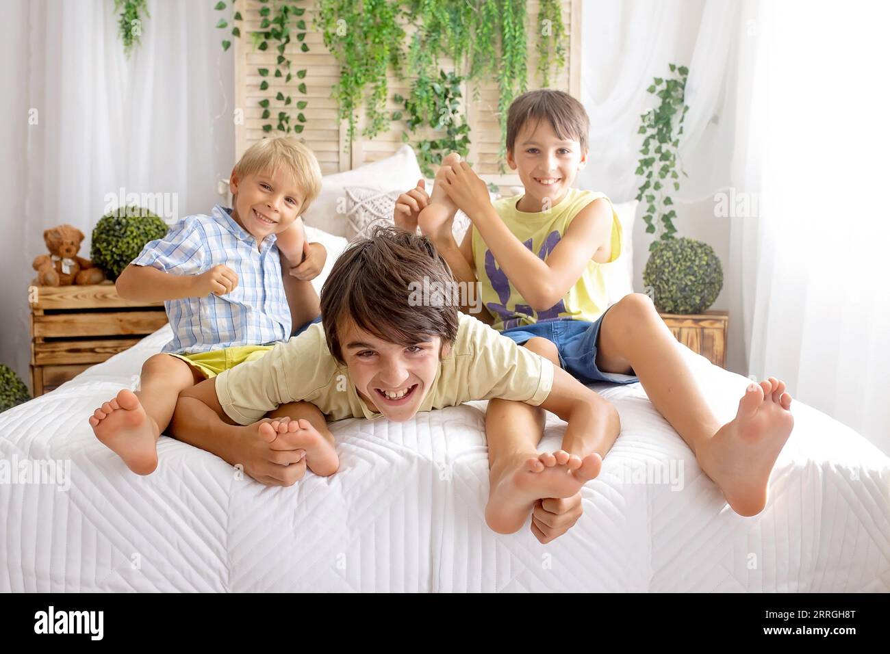 Happy positive children, tickling on the feet, having fun together, boy ...