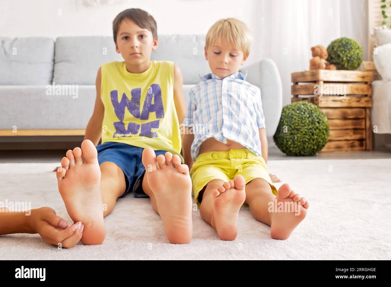 Happy positive children, tickling on the feet, having fun together, boy ...