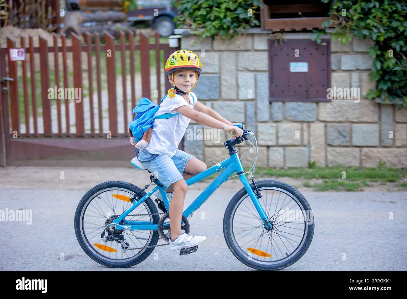 Cute child, boy with helmet and backpack, riding bike at the evening in ...