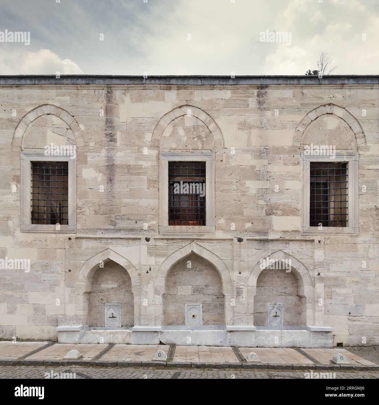 External stone wall of 16th century historic Atik Valide Mosque with ...