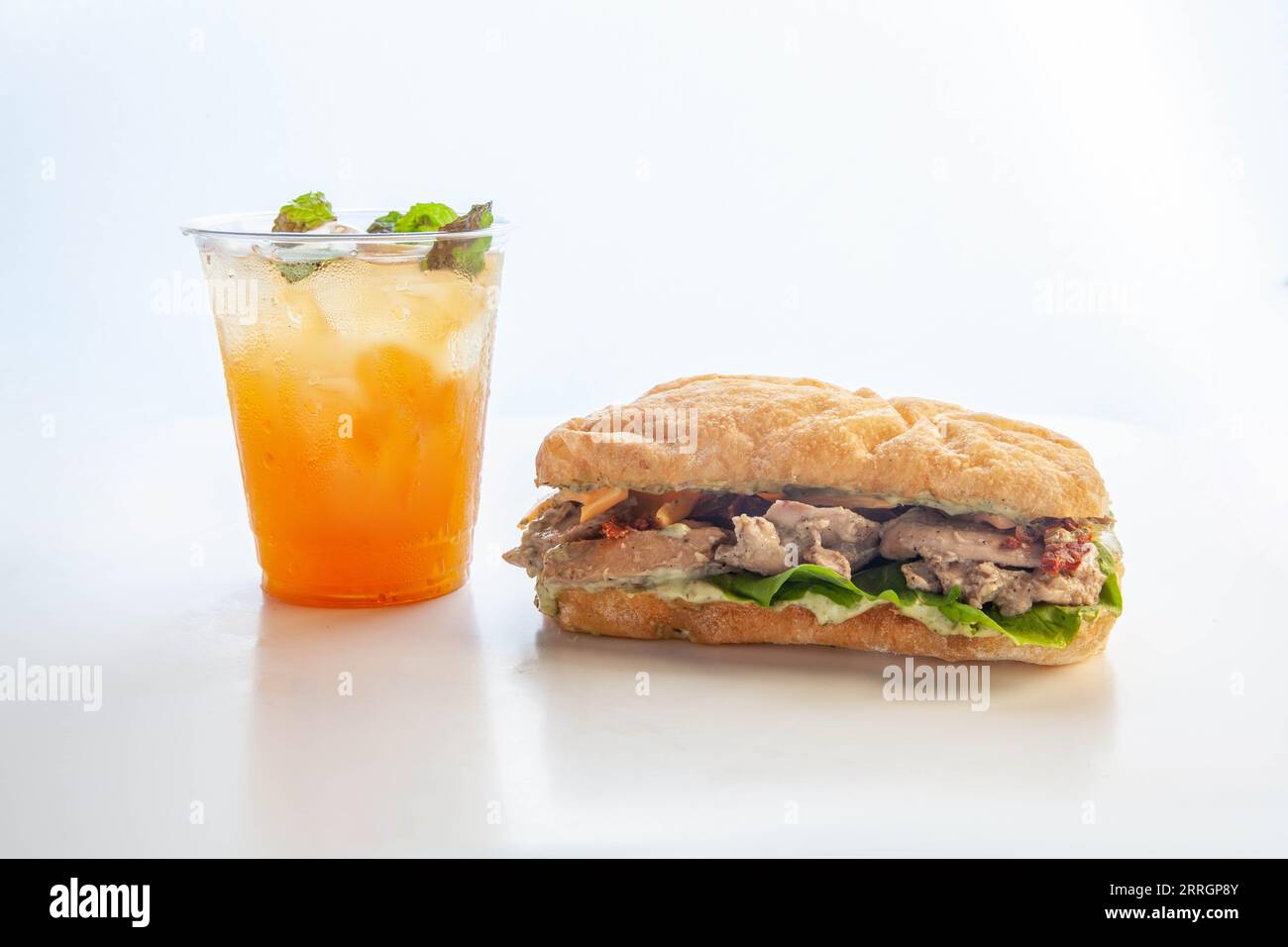 Pesto chicken sandwich in panini bread with iced cold peachy mango ...