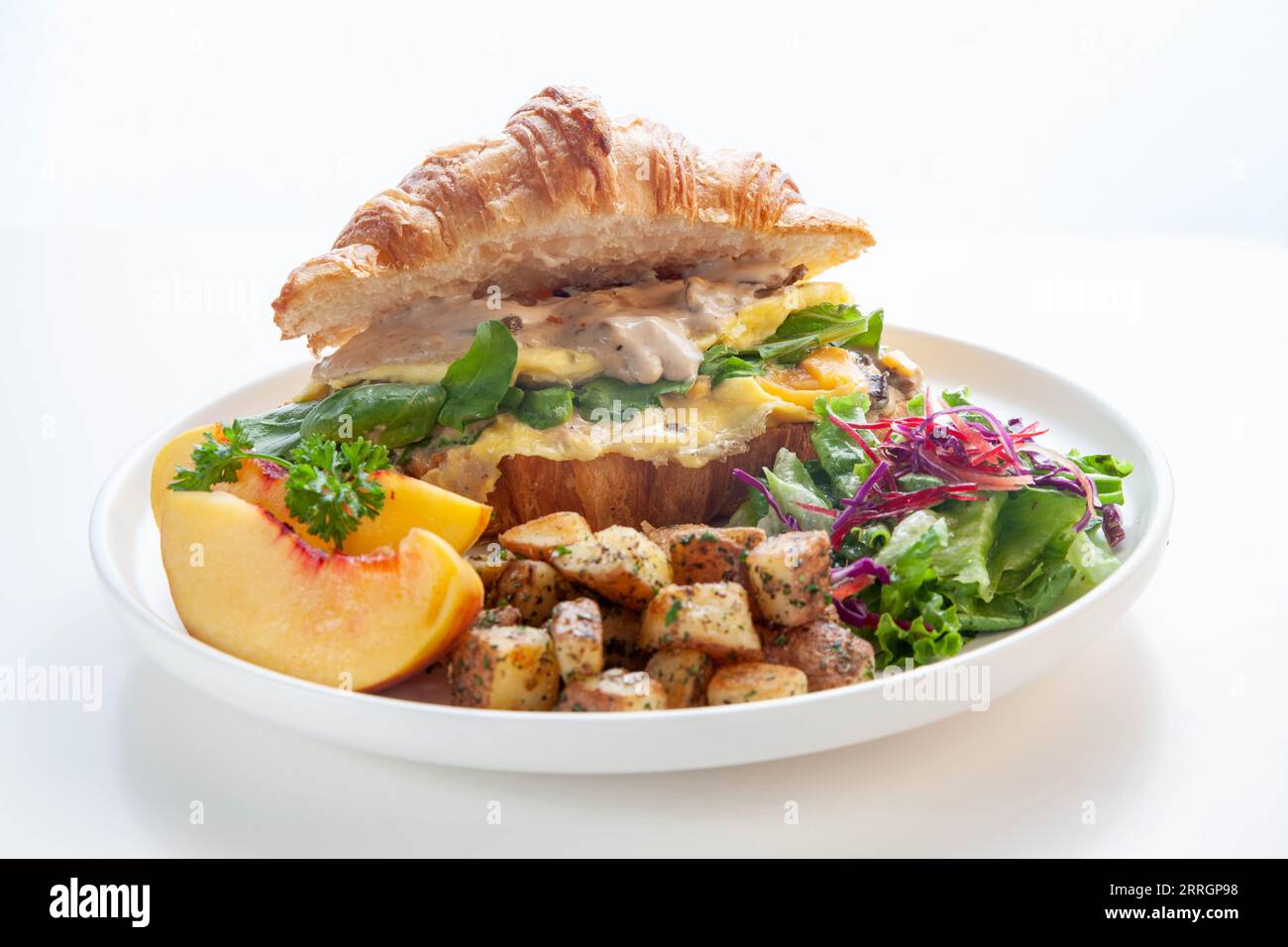 Brioche croissant scrambled egg Benedict with mushrooms and cream with ...