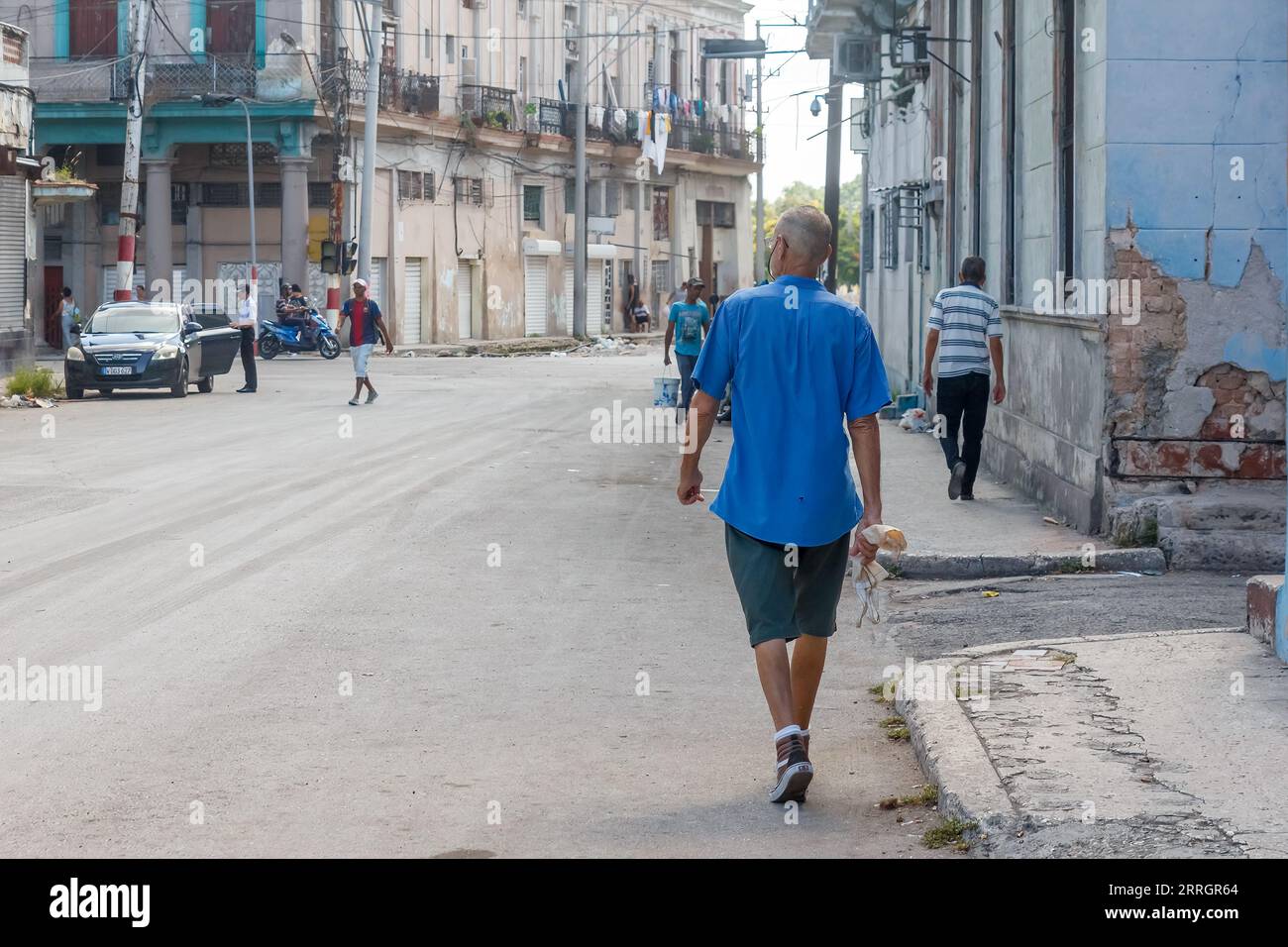 Havana, Cuba - September 3, 2023: Cuban people walking on a city street where buildings are ...