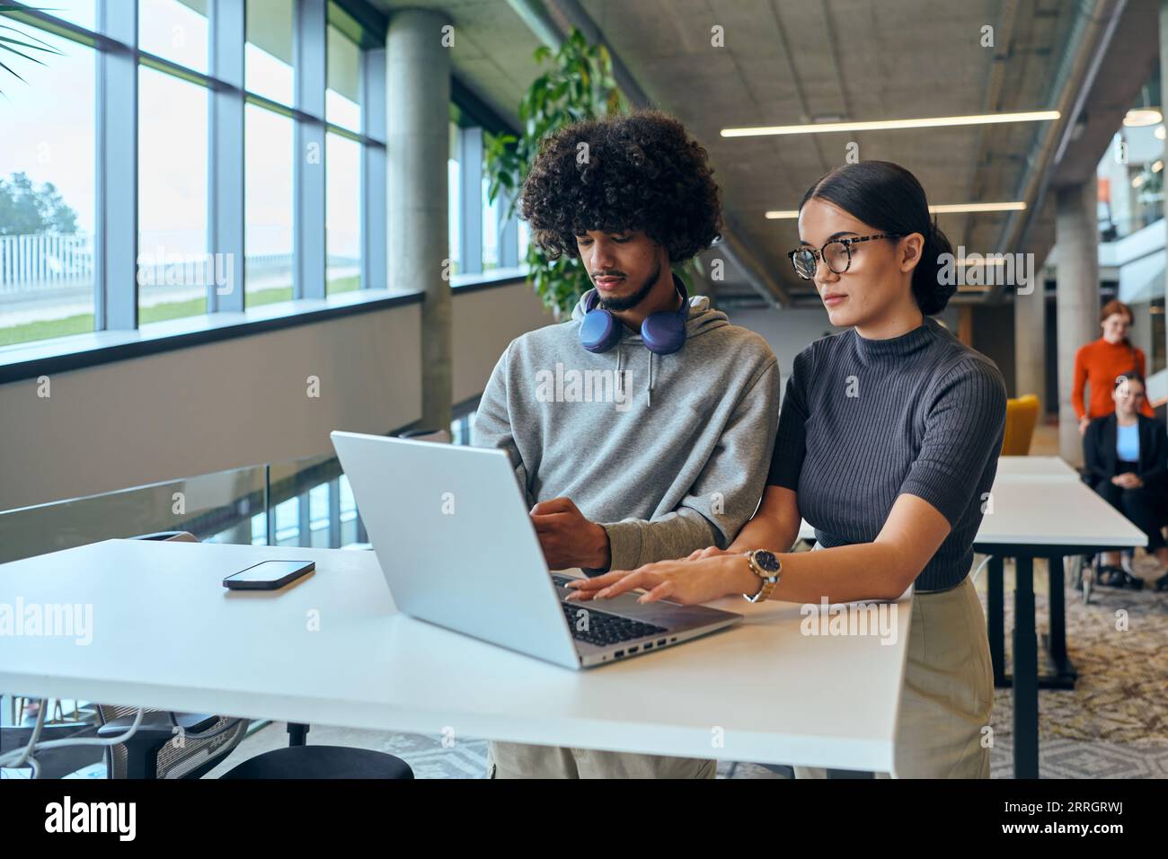 In a contemporary corporate setting, a diverse team of young business ...