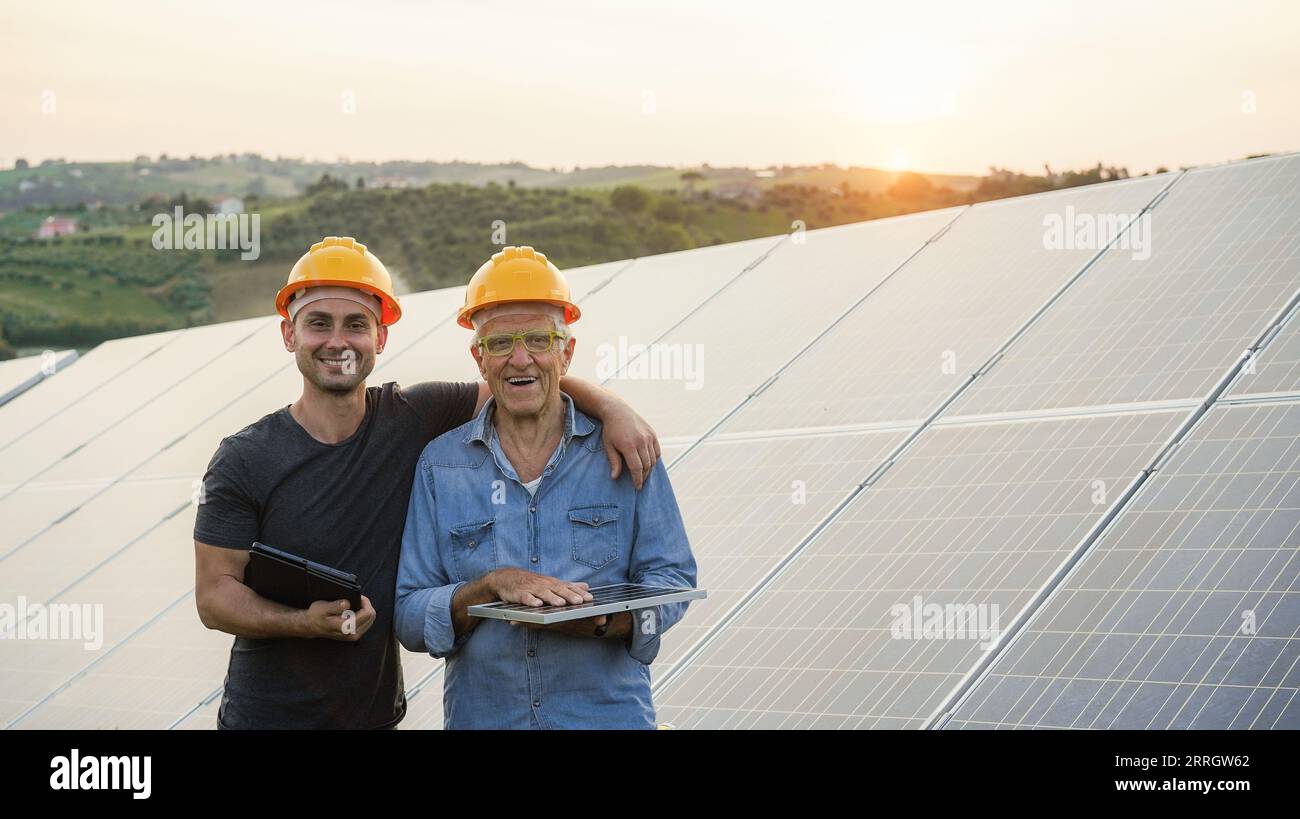 Multigenerational engineers working at solar panels factory outdoor ...