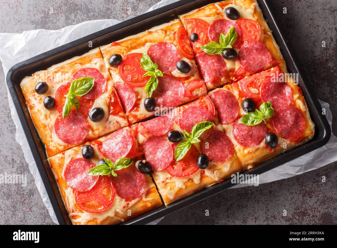 Homemade sliced rectangular pizza with mozzarella, salami sausage ...