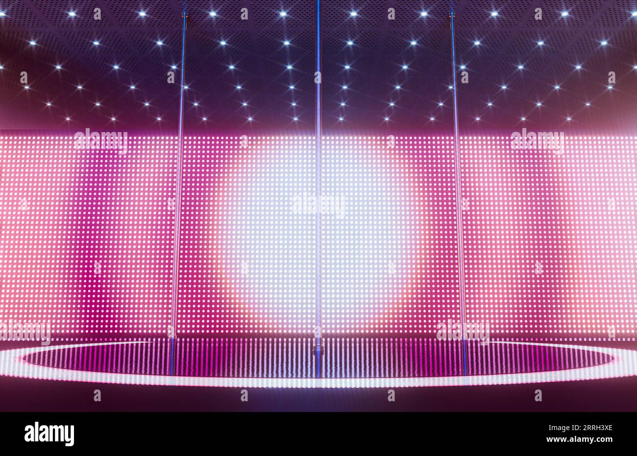 An empty strip club dancing stage with three poles and an illuminated ...