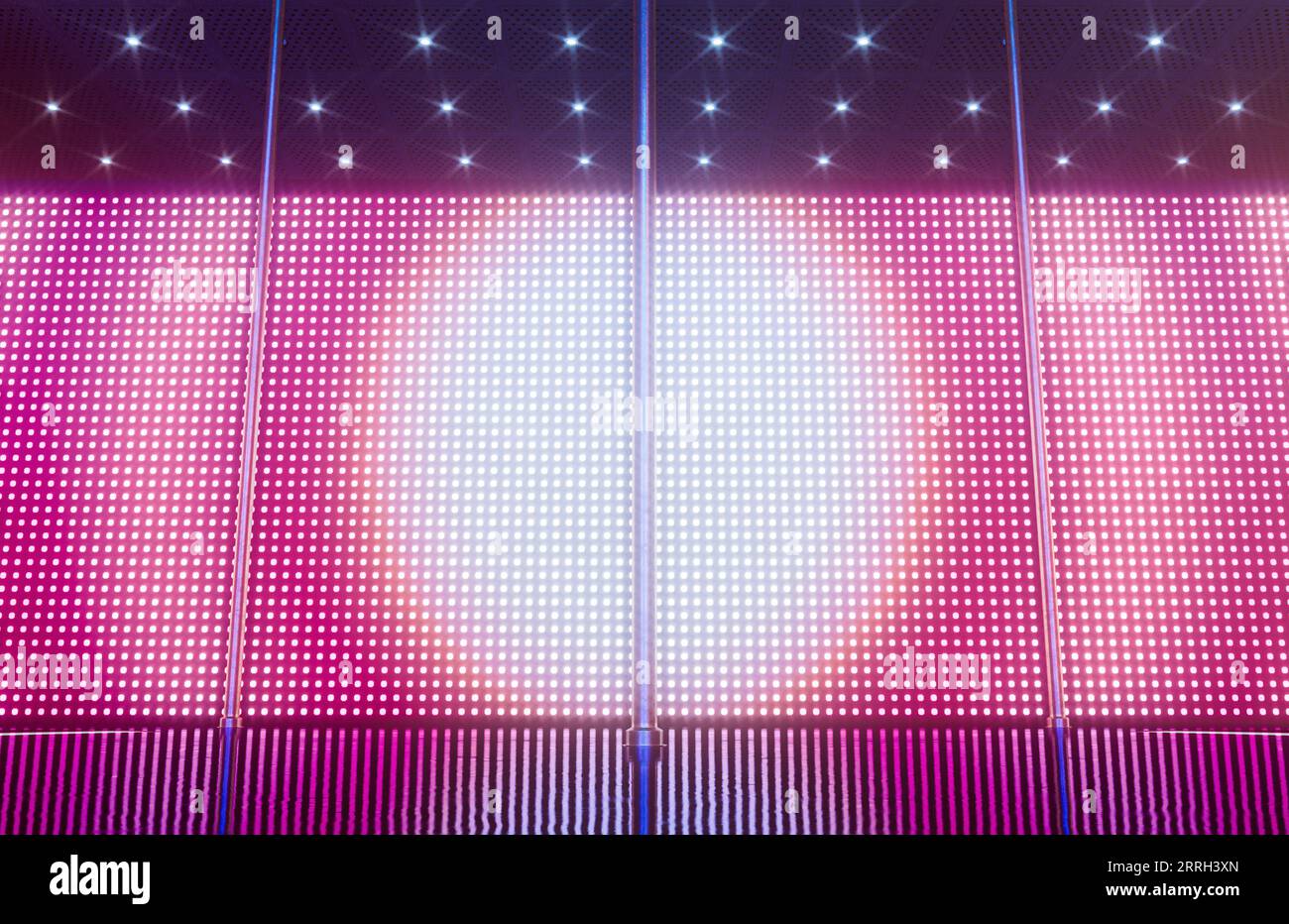 An empty strip club dancing stage with three poles and an illuminated ...