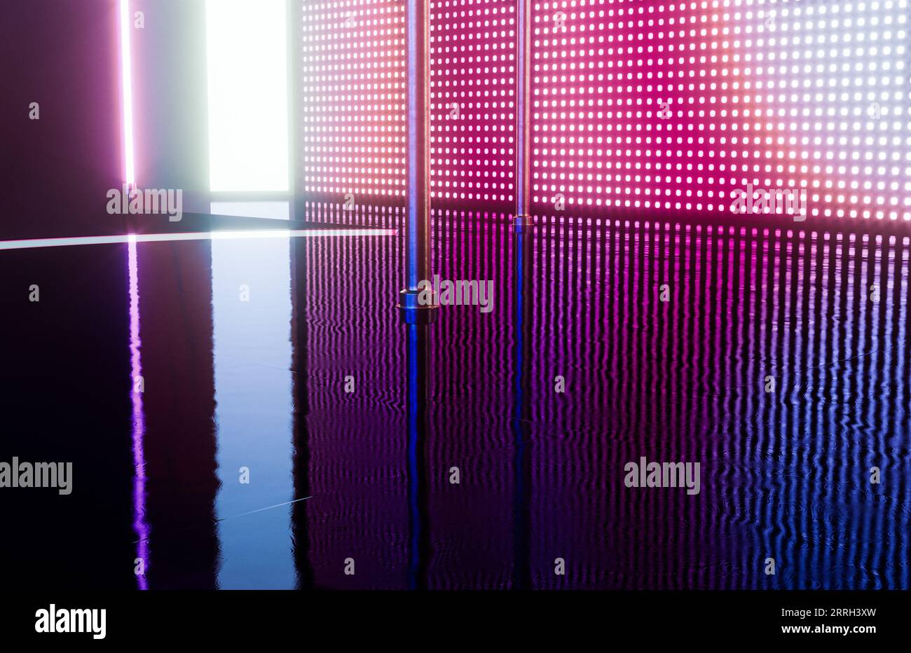 An empty strip club dancing stage with three poles and an illuminated ...
