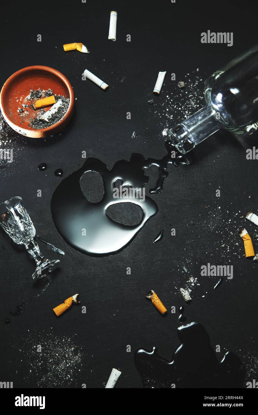 Skull-shaped puddle pours out of a vodka bottle. Cigarette butts are ...