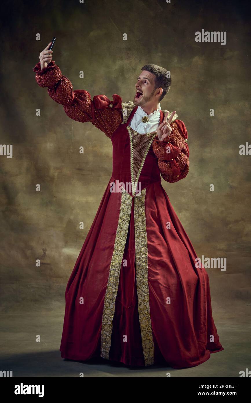 Young man, medieval royal person in female attire taking selfie with ...