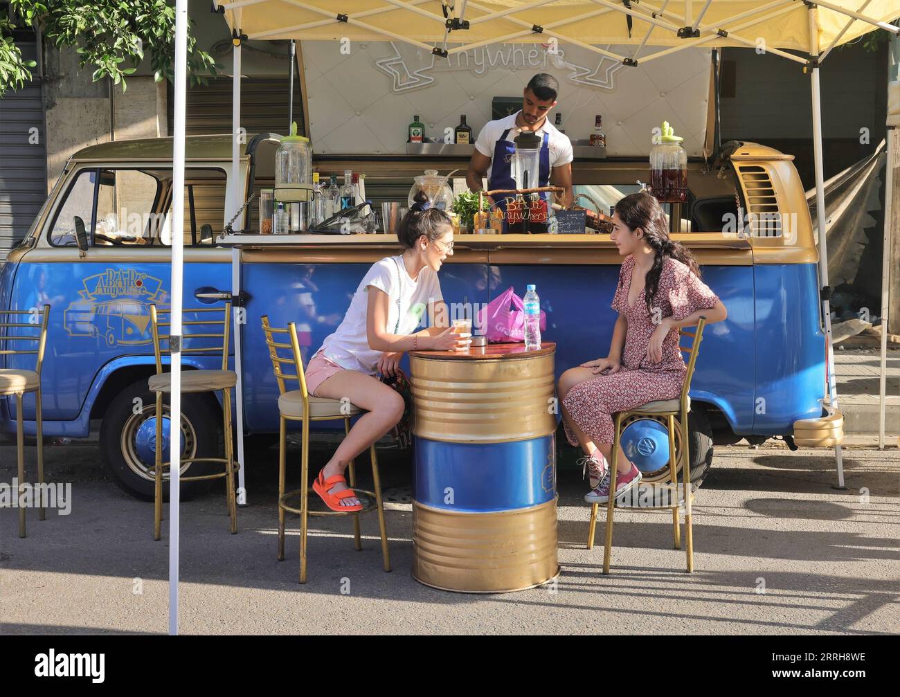 220620 -- BEIRUT, June 20, 2022 -- Two young women drink and chat at a ...