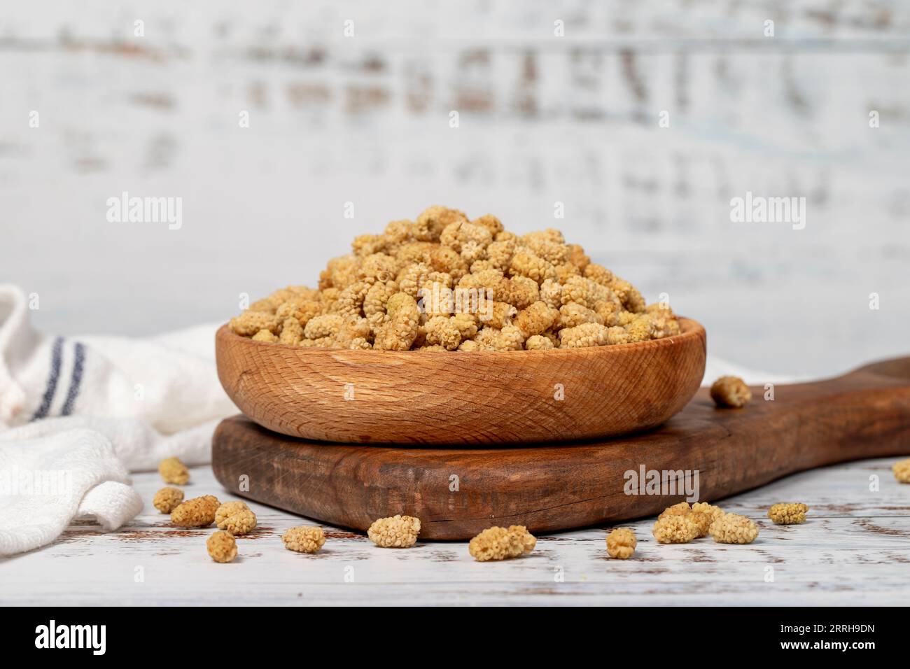 Dried mulberries in wooden bowl. Sun-dried mulberry on a white wood ...
