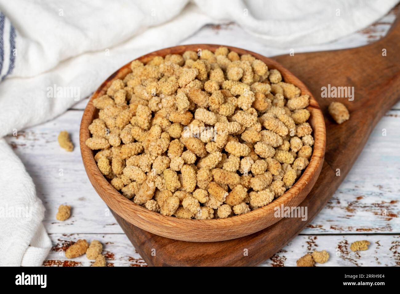 Dried mulberries in wooden bowl. Sun-dried mulberry on a white wood ...