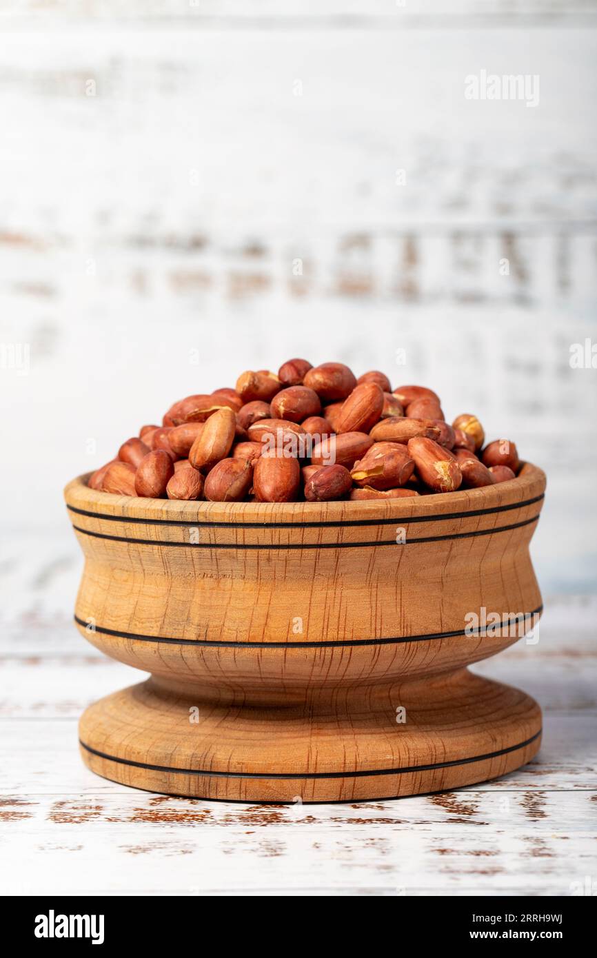 Peanuts in wooden bowl. Peanuts in shell on white wood background Stock ...