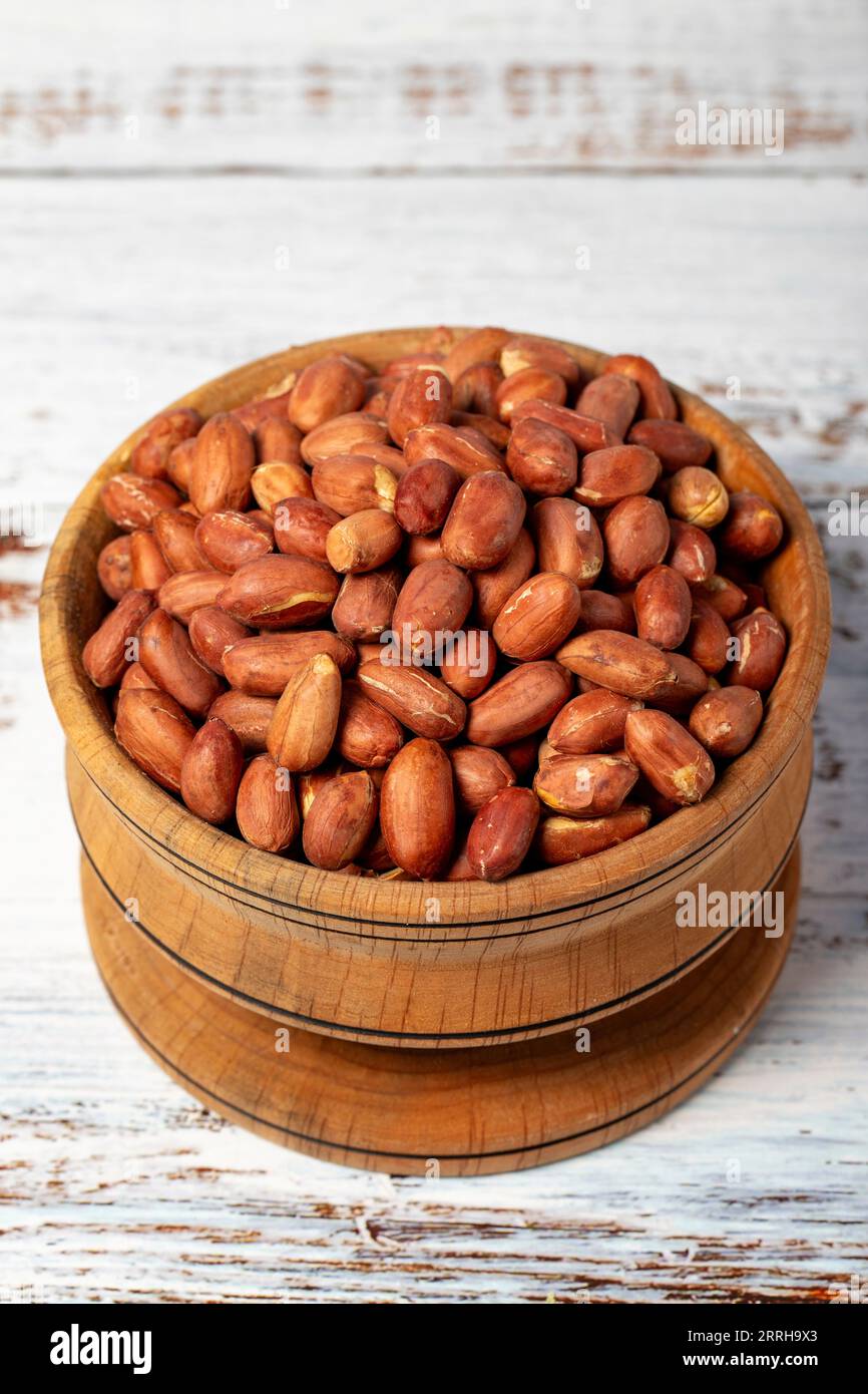 Peanuts in wooden bowl. Peanuts in shell on white wood background ...