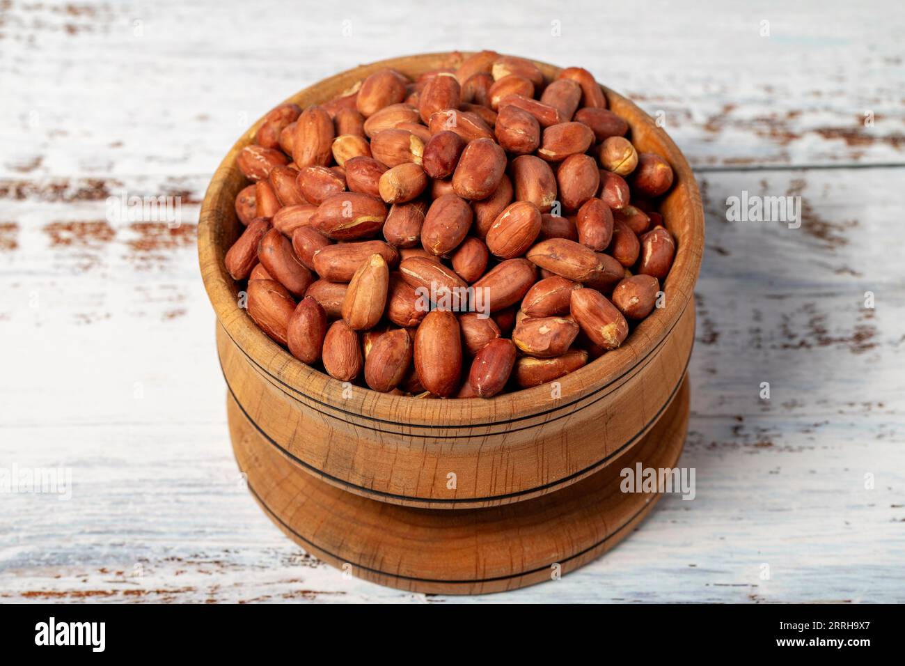Peanuts in wooden bowl. Peanuts in shell on white wood background Stock ...