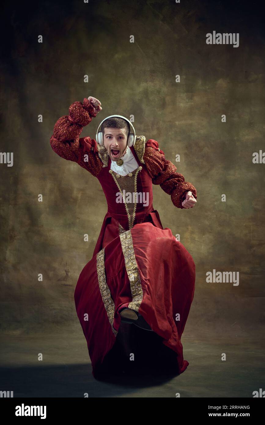 Young man, medieval prince, monarch in female dress listening to music ...