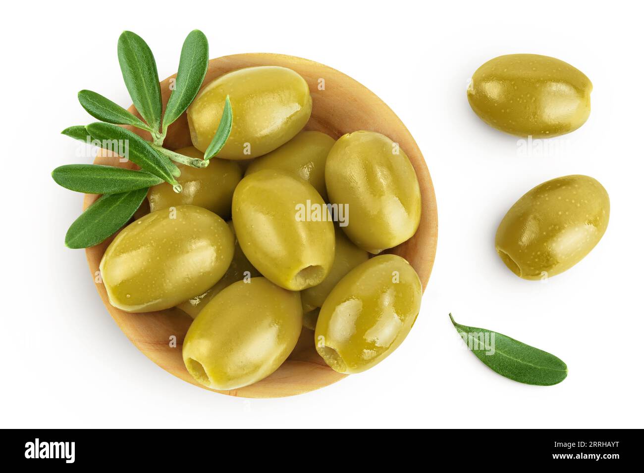 Green olives with leaves in wooden bowl isolated on a white background ...