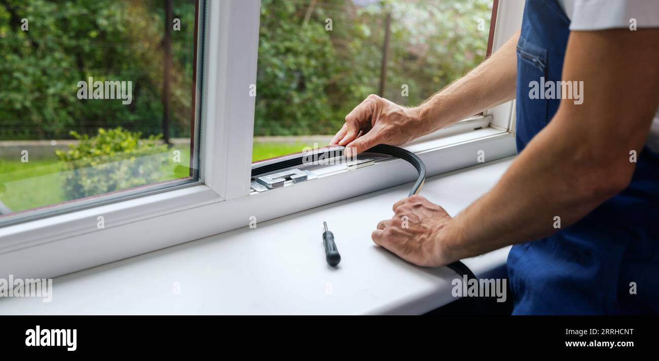 worker installing sealing tape on plastic window frame. banner with ...