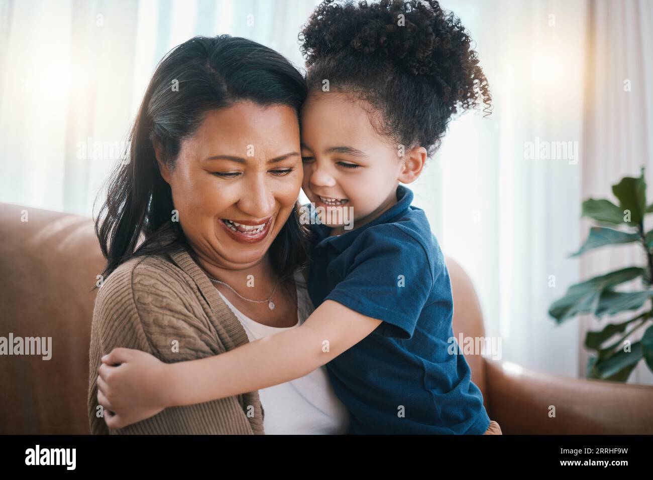 Love, mother and child hug happy with care on a home couch together bonding as family with ...