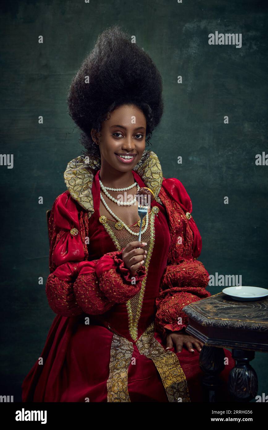 Young african woman, medieval queen, princess in red dress eating ...