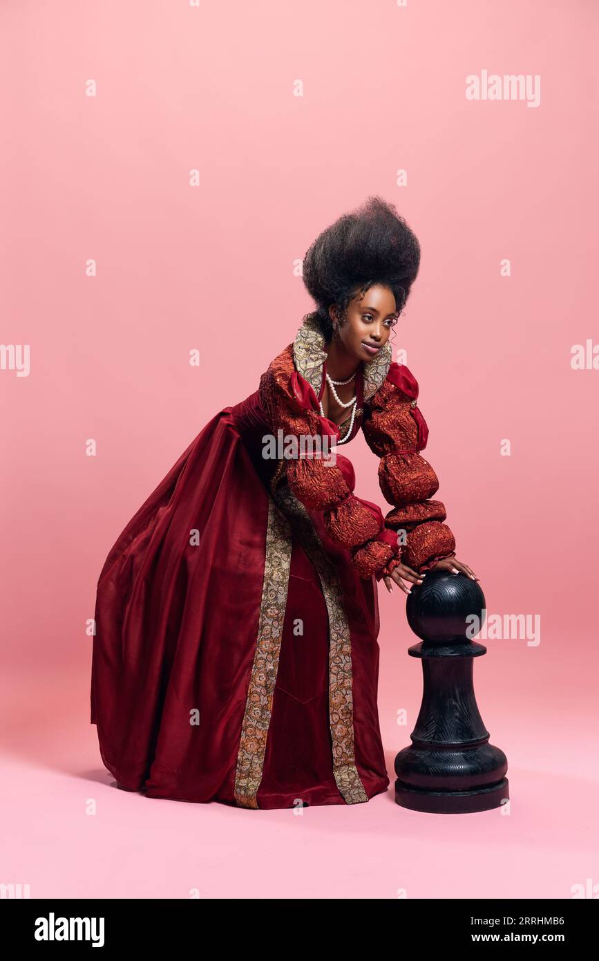 Checkmate. Portrait of medieval princess, queen in red costume playing ...