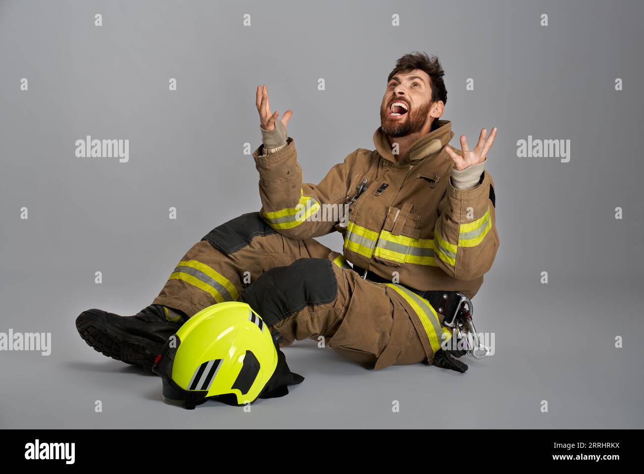 Despaired bearded fireman raising hands, crying after fighting fire in ...