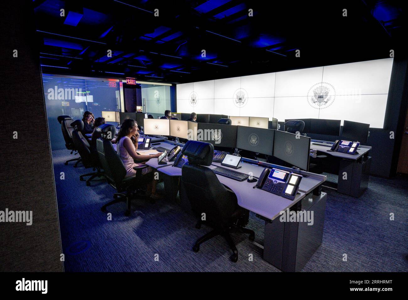 In this image provided by the White House, people sit at desks on the ...