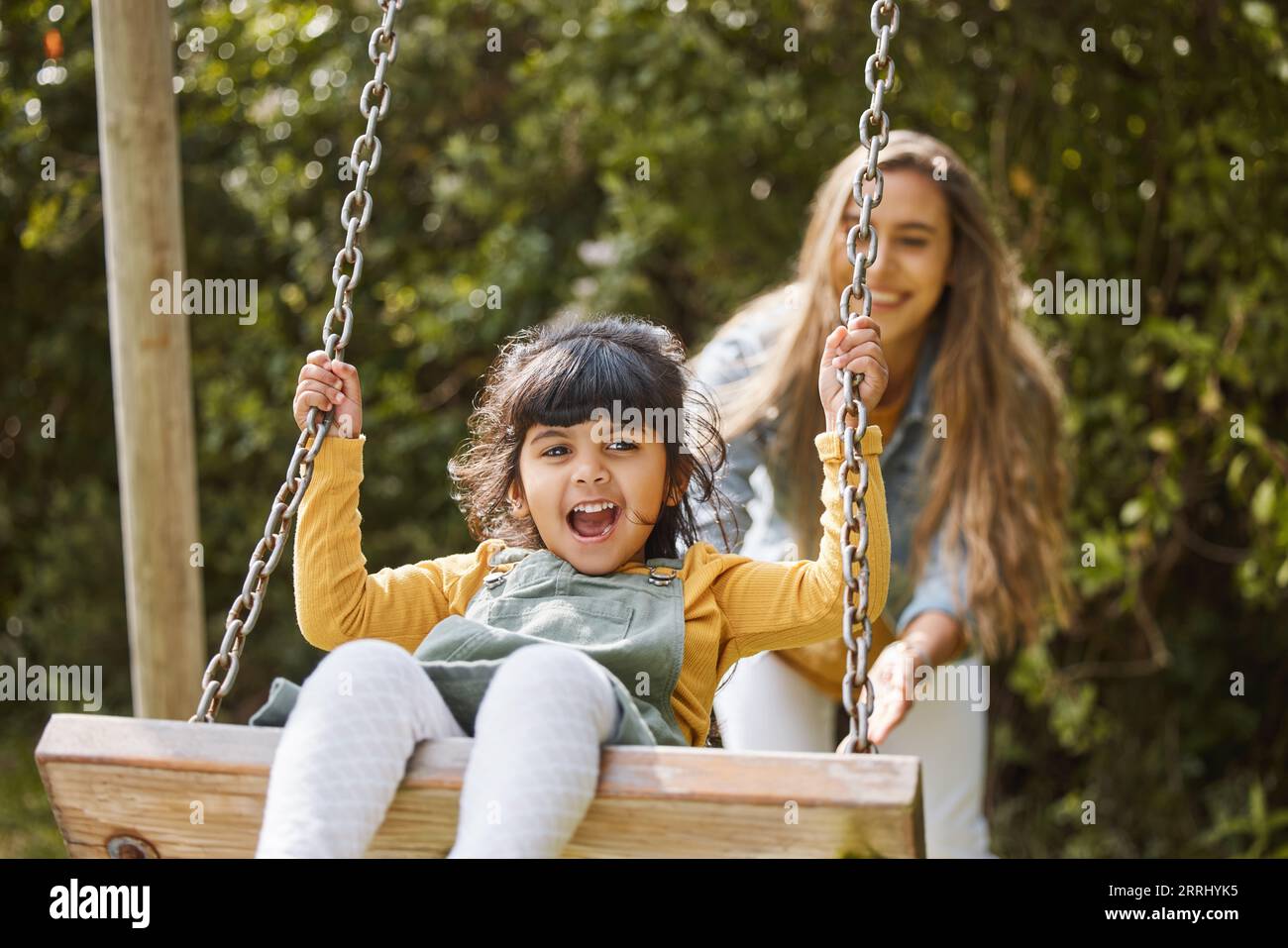Happy, swing and mother and child in park for playing, bonding and ...
