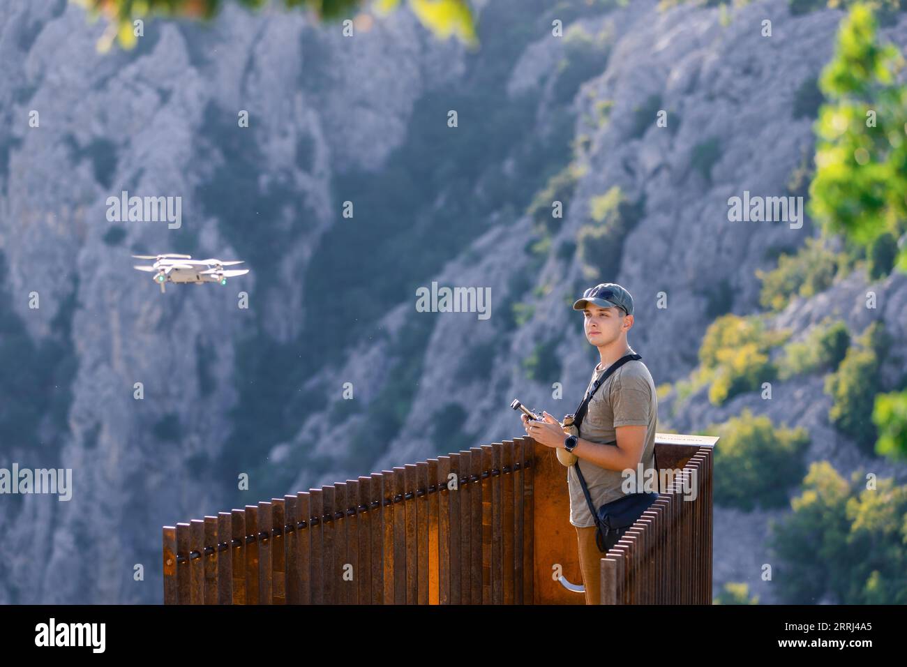 A young male flying by drone in the mountains. Aerial photography ...
