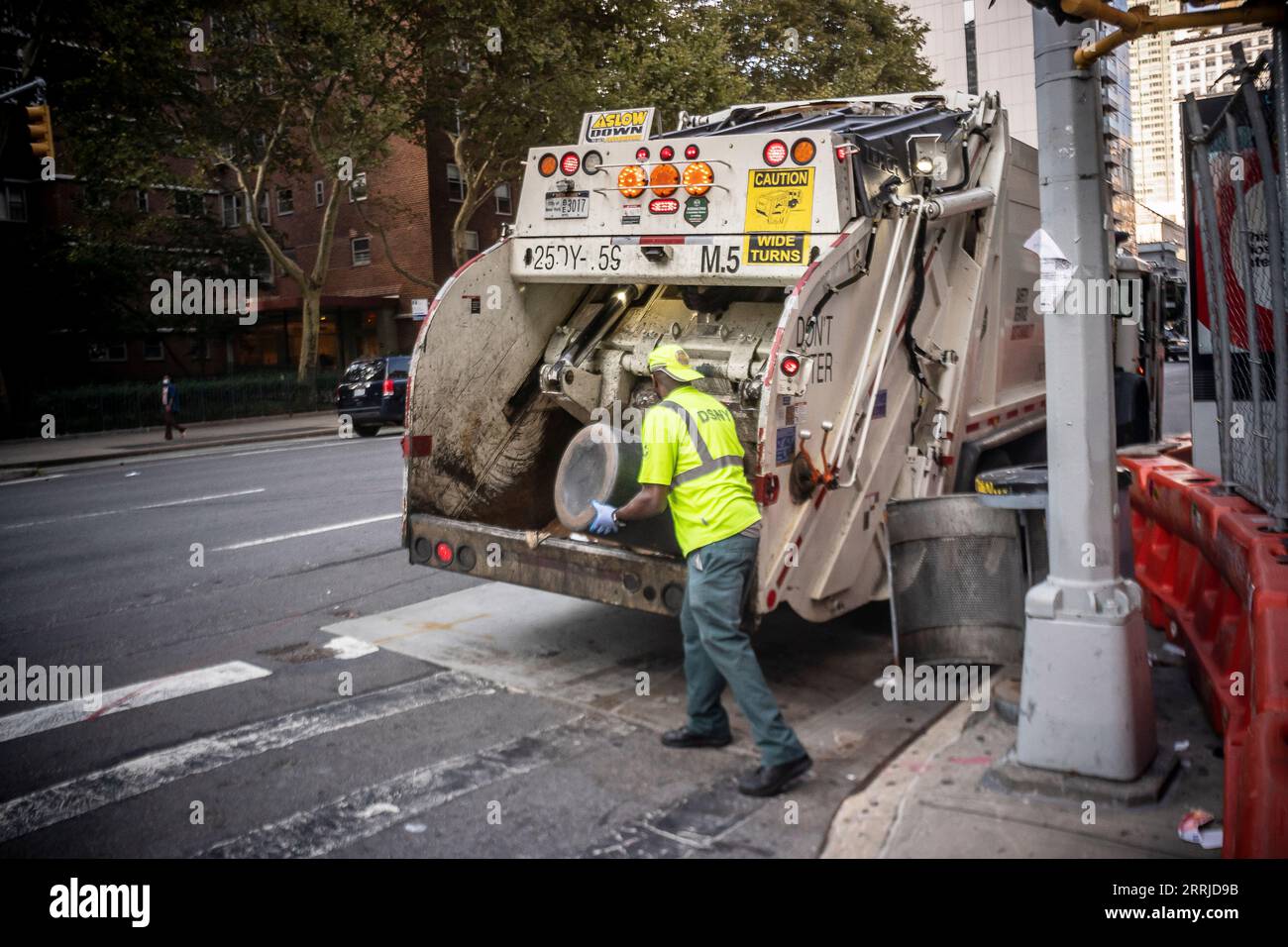 A New York City Department of Sanitation worker loads his truck in the ...