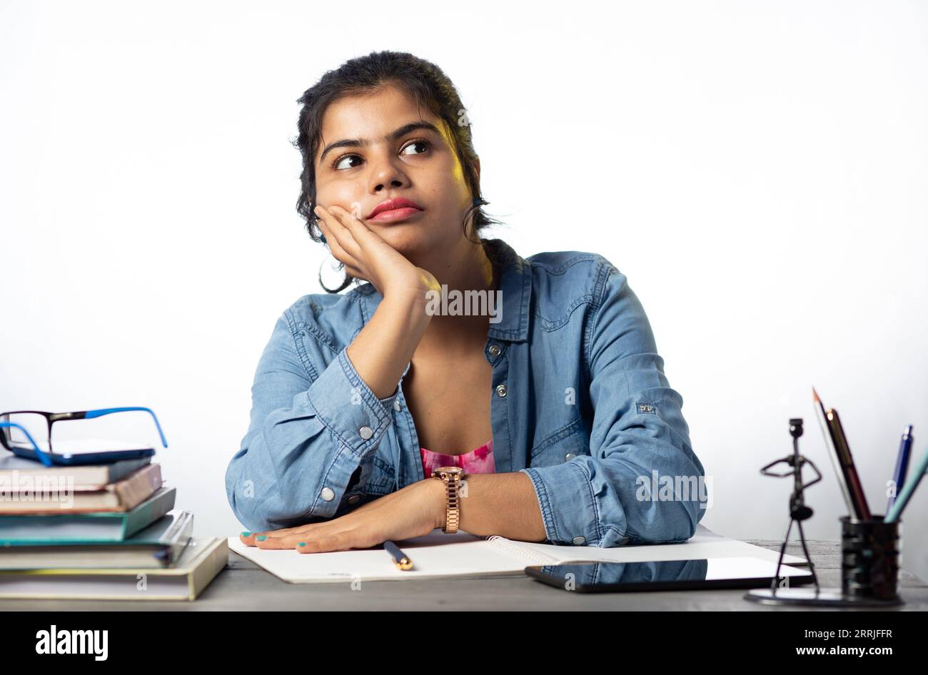 A pretty young Indian college student thinking while studying n study ...