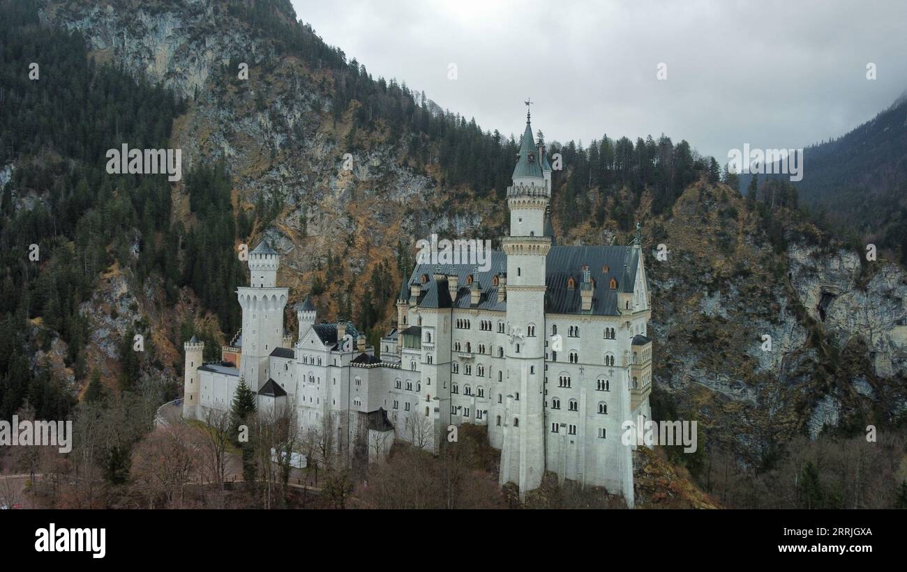 An aerial view of the historic Neuschwanstein Castle on top of a lush ...