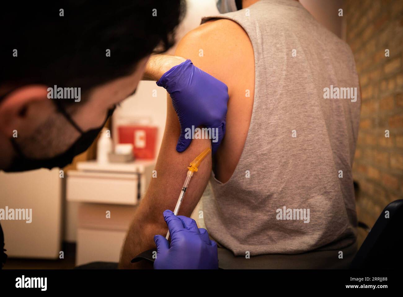 220726 -- CHICAGO, July 26, 2022 -- A medical worker gives a dose of ...