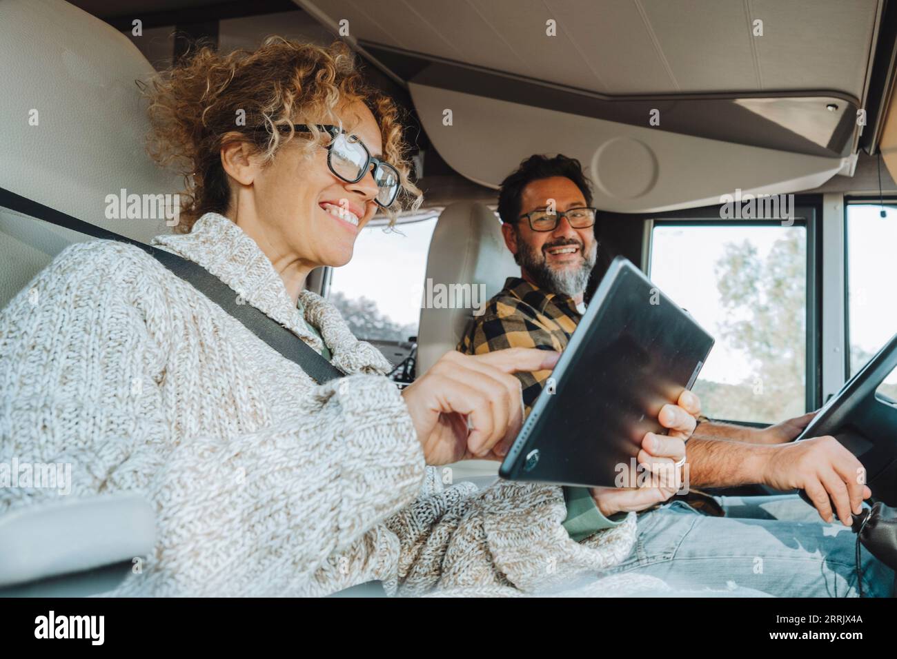People using tablet device during travel vacation inside camper van ...