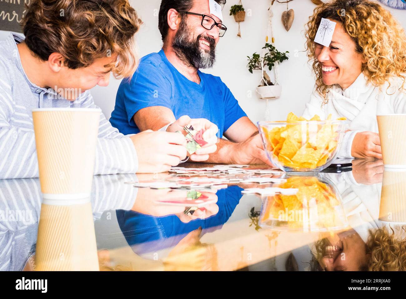 Happy real people family play together with cards at home on the table ...