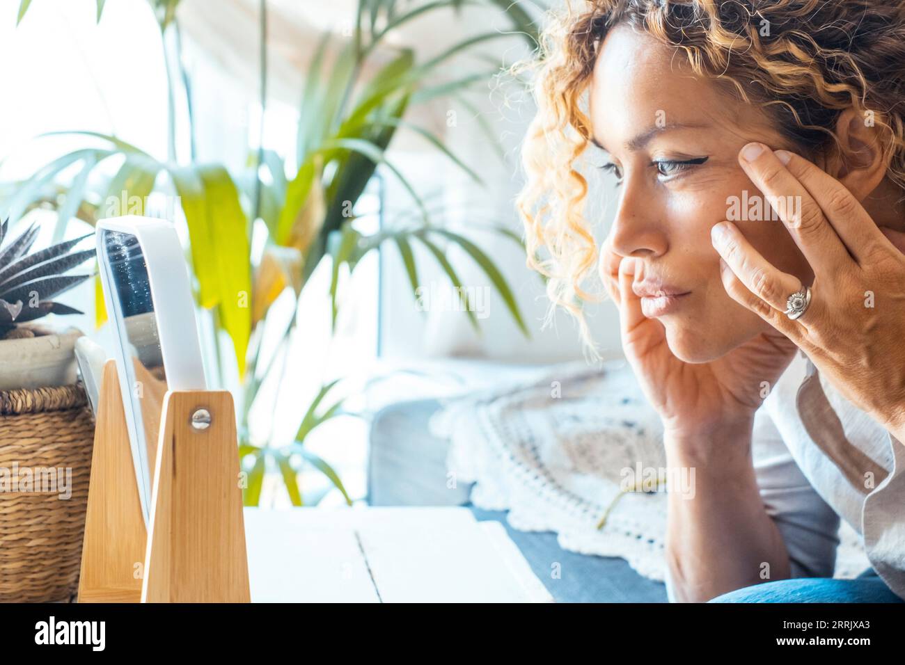 Close up of adult woman checking face for wrinkles. Aging issue. One ...