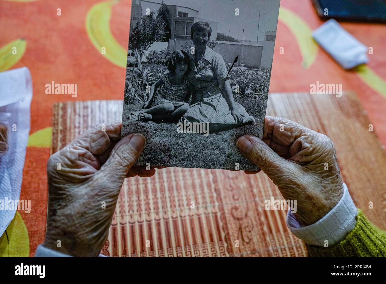 Eliana Rodríguez holds a photograph of herself with her daughter Yelena ...