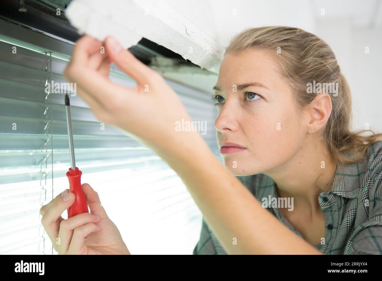 a woman is installing window Stock Photo - Alamy