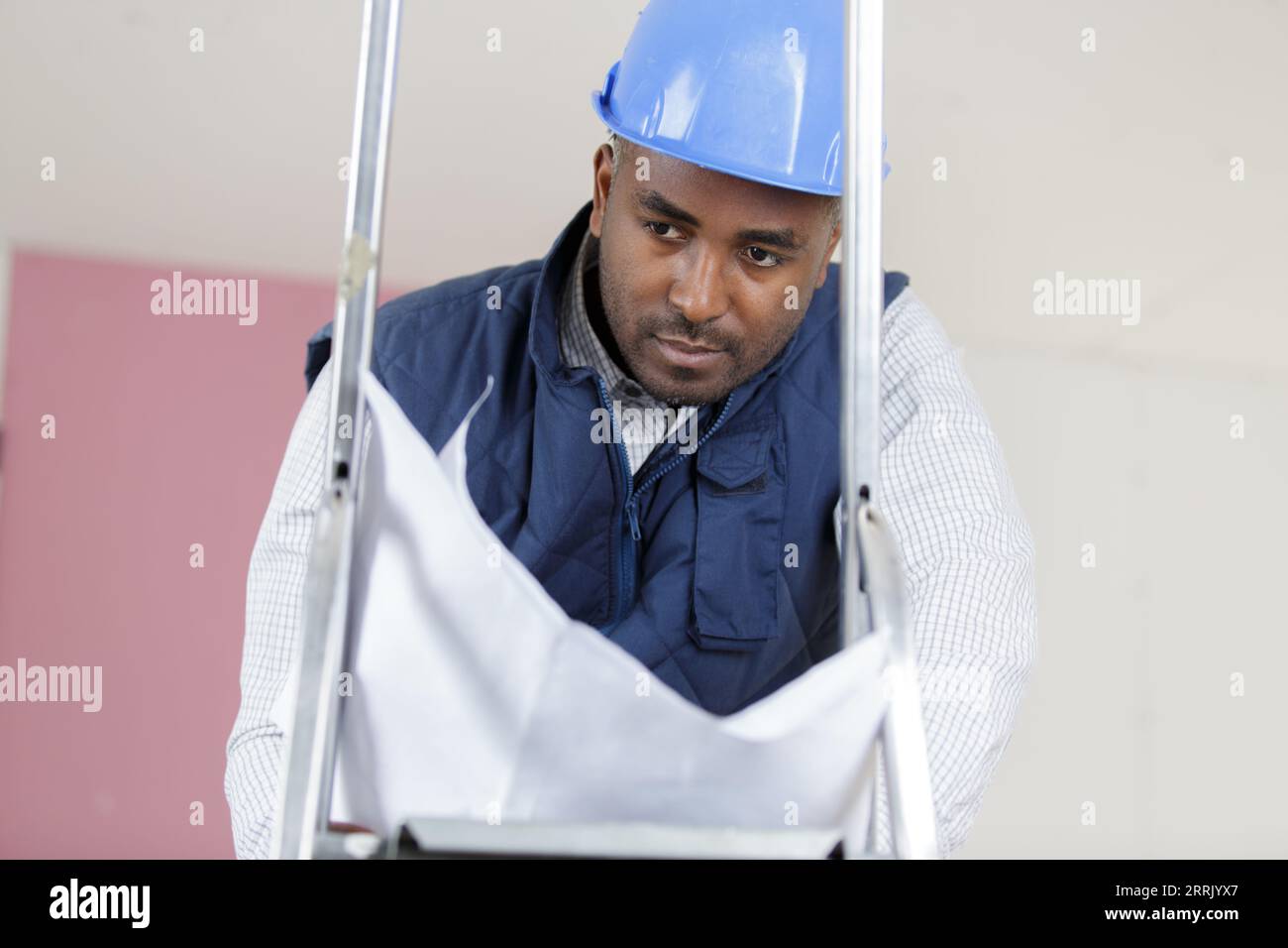 male builder on ladder reading Stock Photo - Alamy