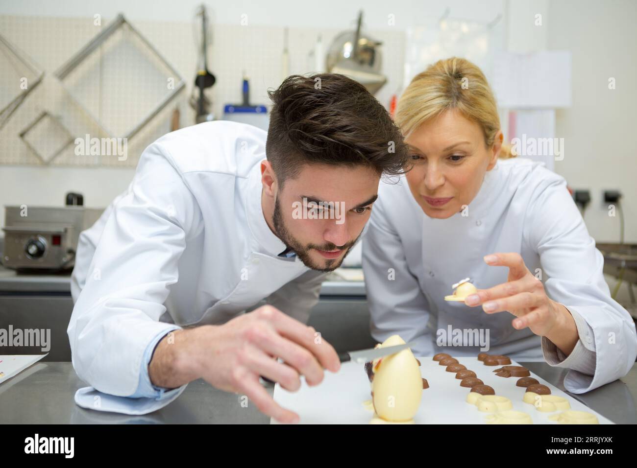 two chefs decorating chocolate egg Stock Photo - Alamy