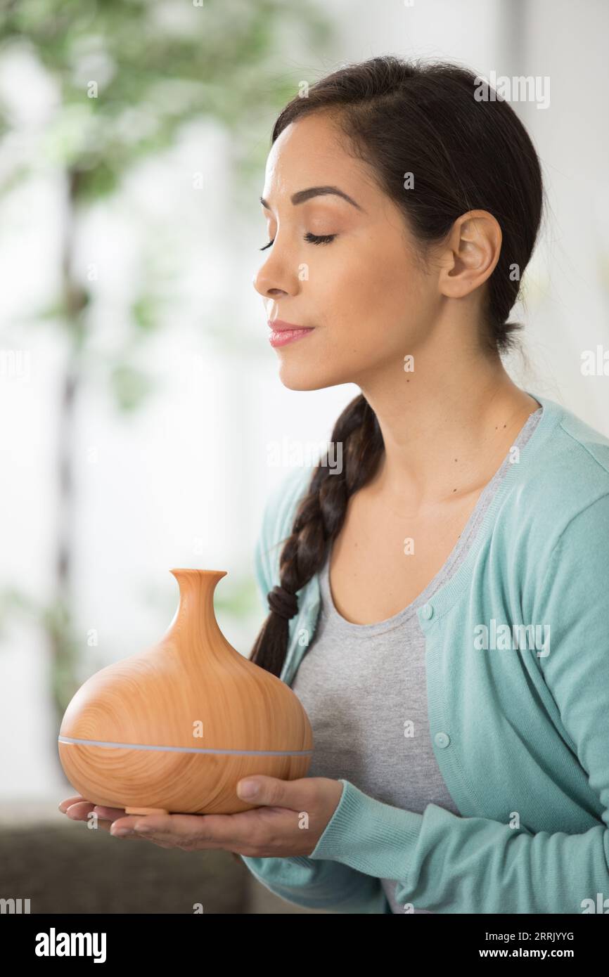beautiful woman smelling steam from aroma diffuser Stock Photo - Alamy