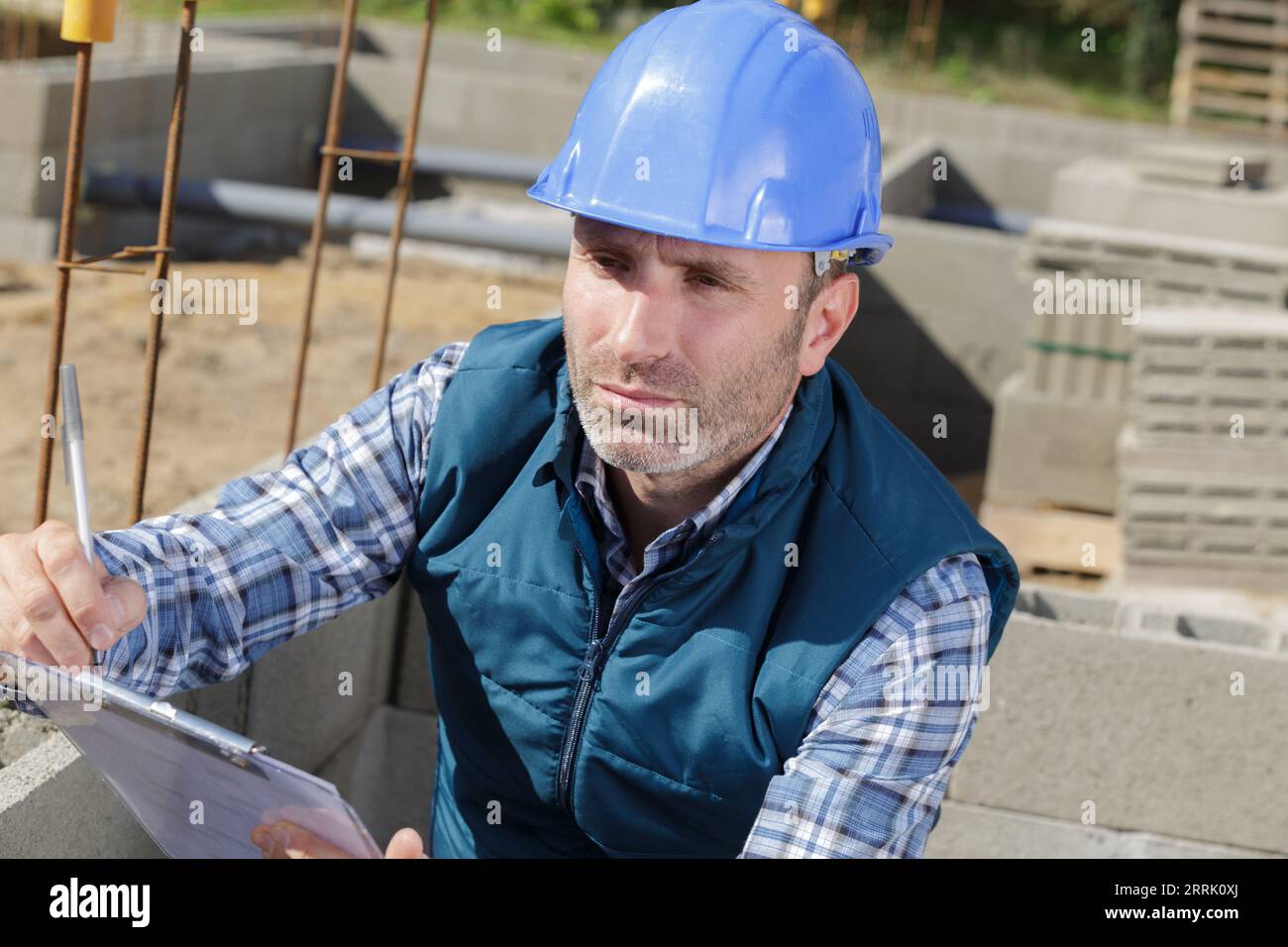 builder in with clipboard in construction site Stock Photo - Alamy
